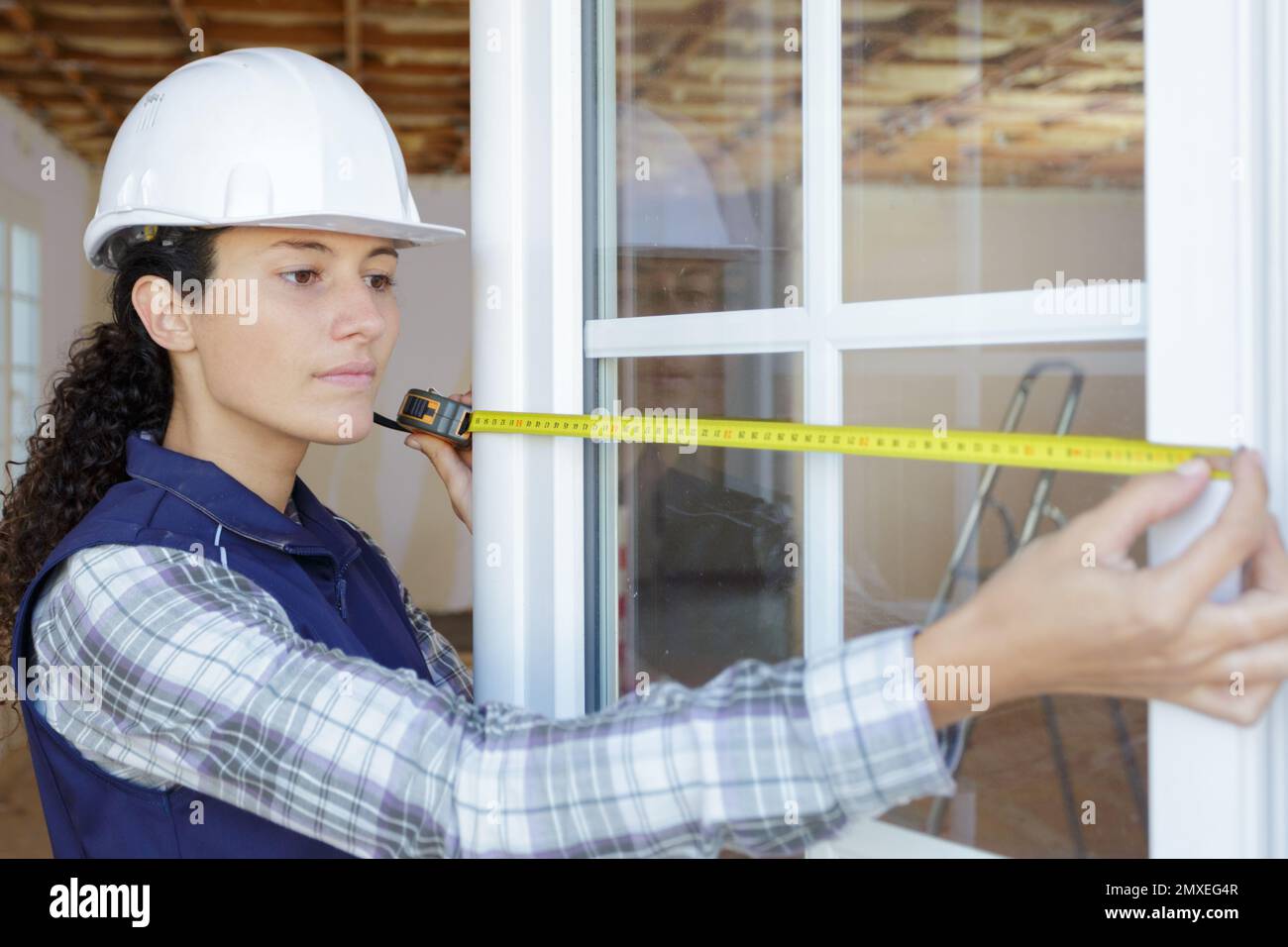 woman in hard hat measuring window Stock Photo - Alamy