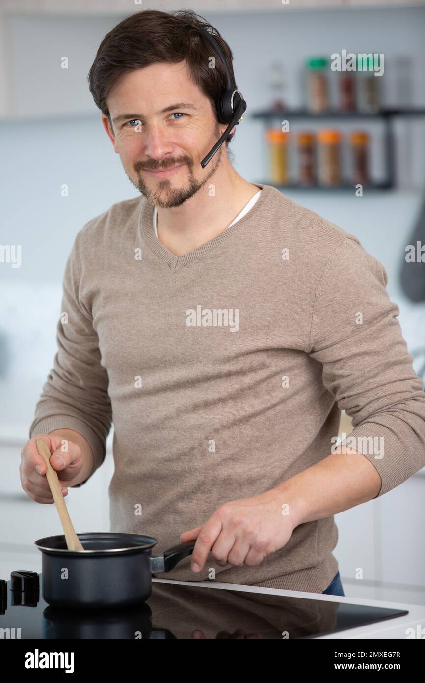 businessman using headphones while cooking Stock Photo - Alamy