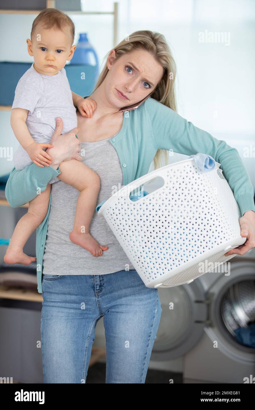 tired young mother doing the laundry with her baby Stock Photo - Alamy