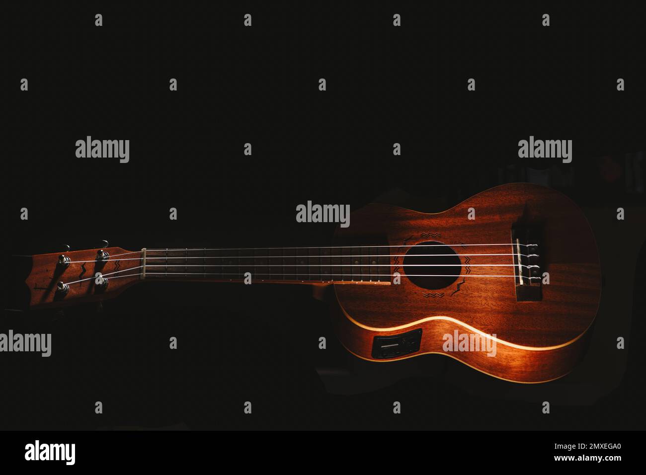 A ukulele stringed musical instrument on a black background Stock Photo ...