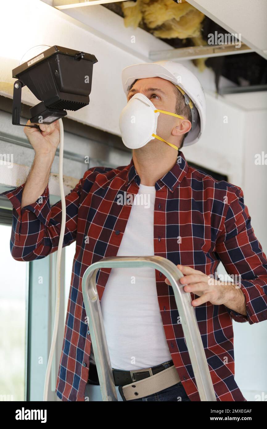 builder using a face mask while lighting in a site Stock Photo - Alamy