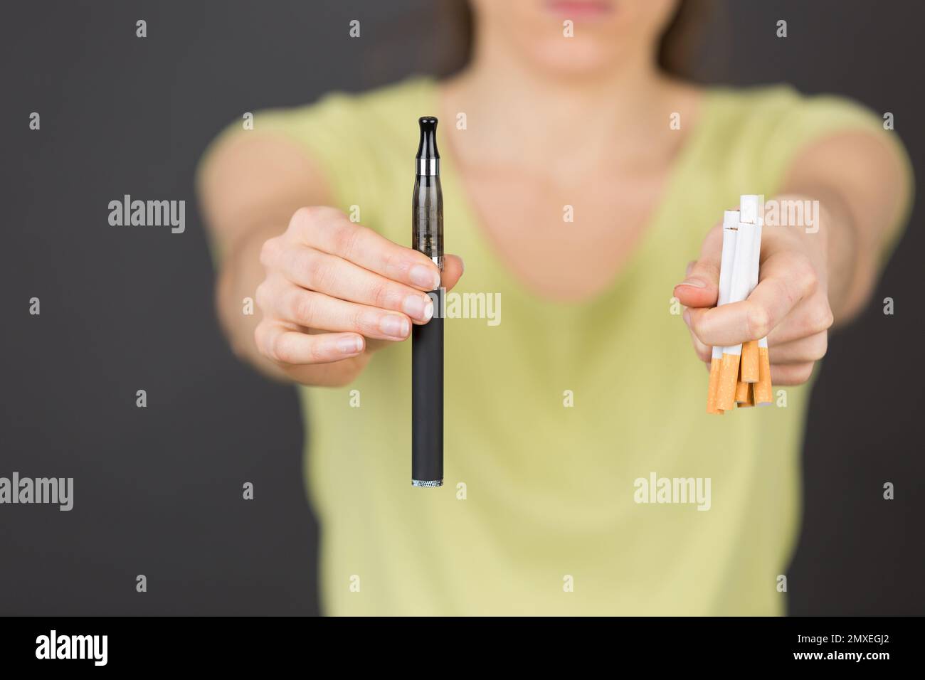 woman holding electronic cigarette and normal cigarette Stock Photo - Alamy