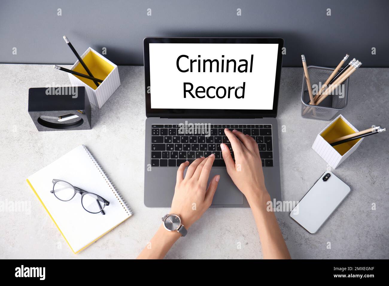 Woman using laptop with words CRIMINAL RECORD at table, top view Stock ...