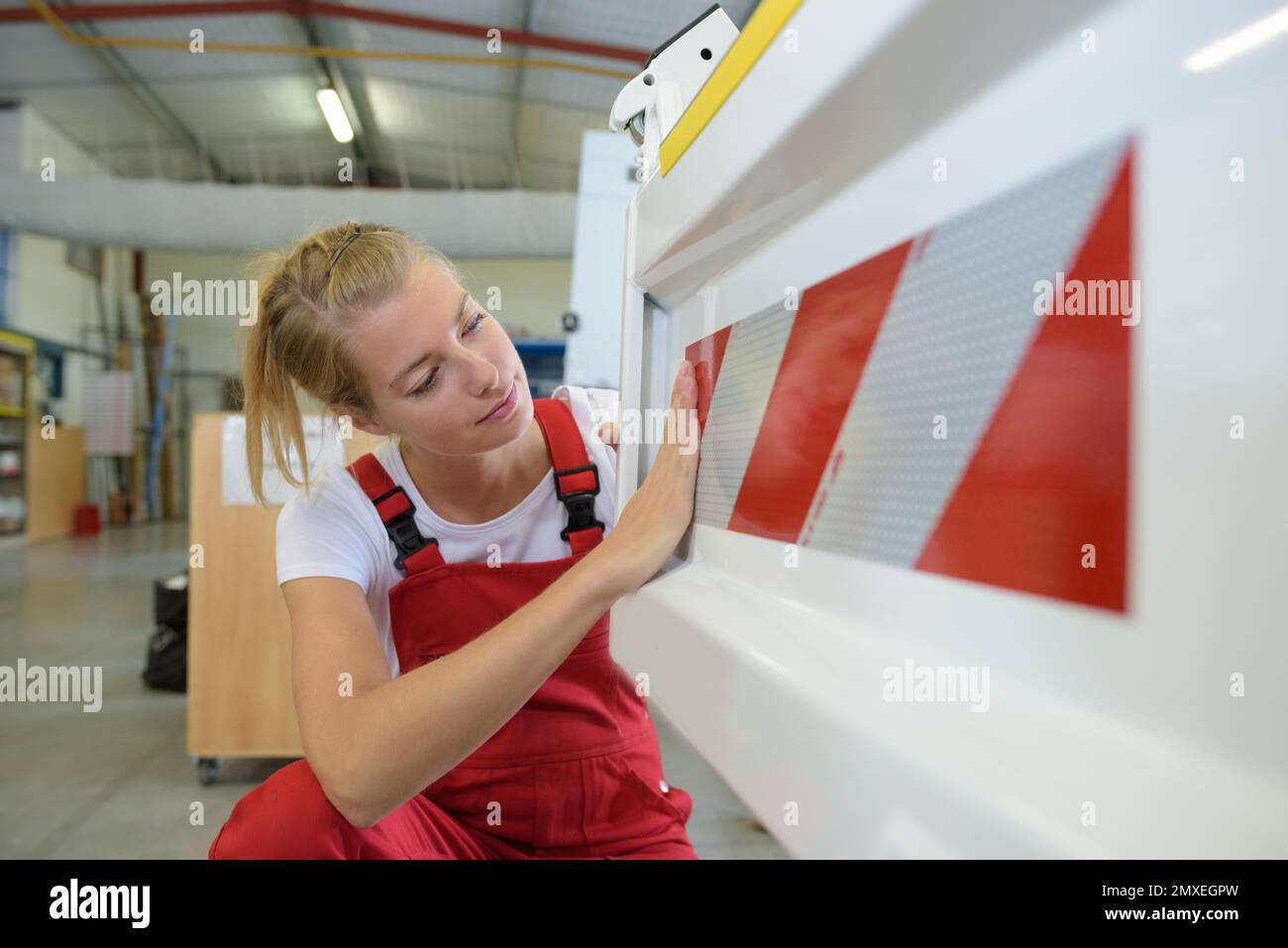 female mechanic applying reflective sticker to a car Stock Photo - Alamy