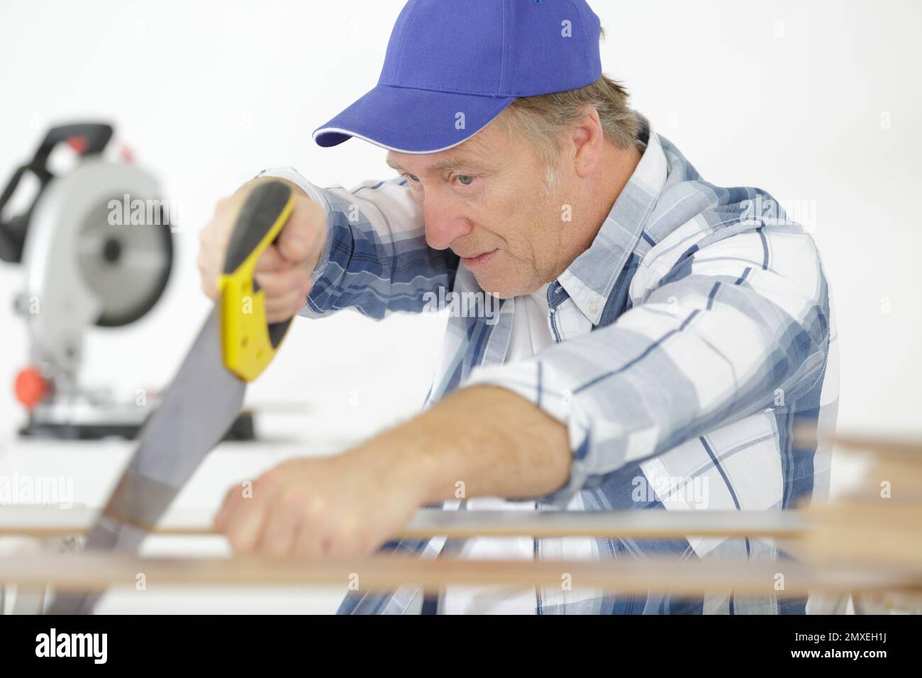 mature man using a hand saw Stock Photo - Alamy