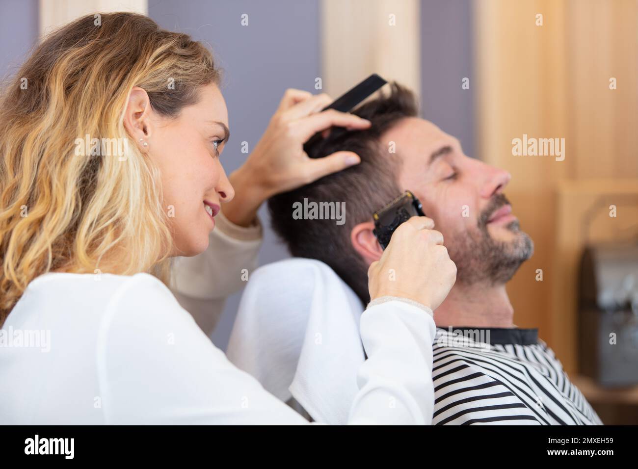 man getting his hair cut by a woman Stock Photo - Alamy
