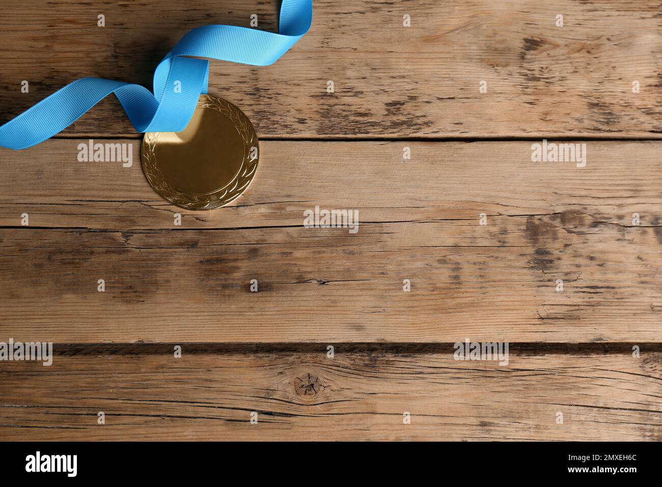 Medal with light blue ribbon on wooden background, flat lay. Space for ...