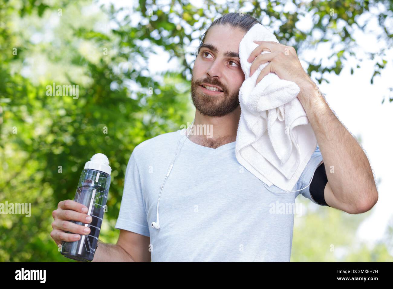 man holding water-bottle and wiping his brow with a towel Stock Photo ...