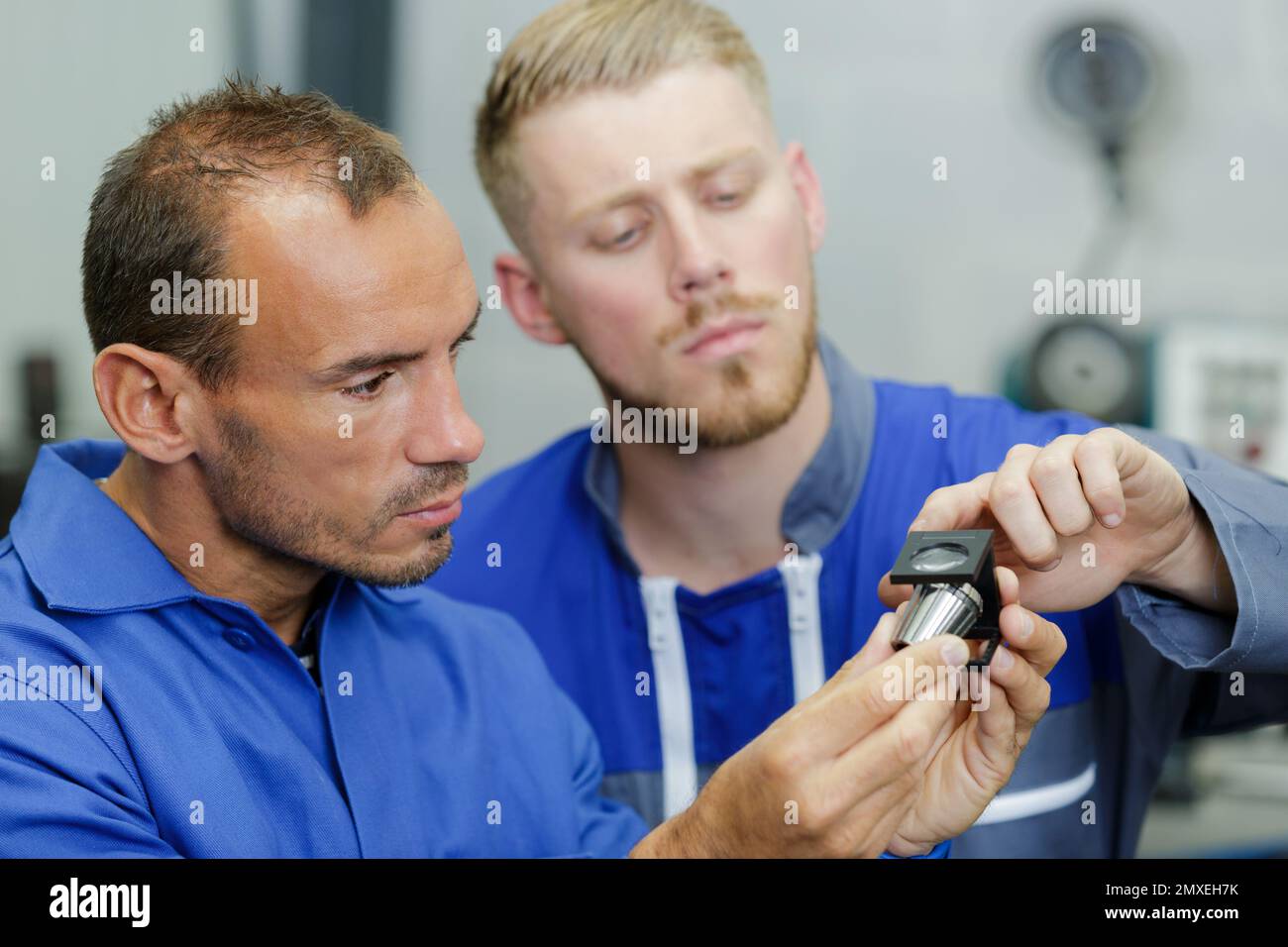 workers using loupe glass to inspect damage Stock Photo - Alamy