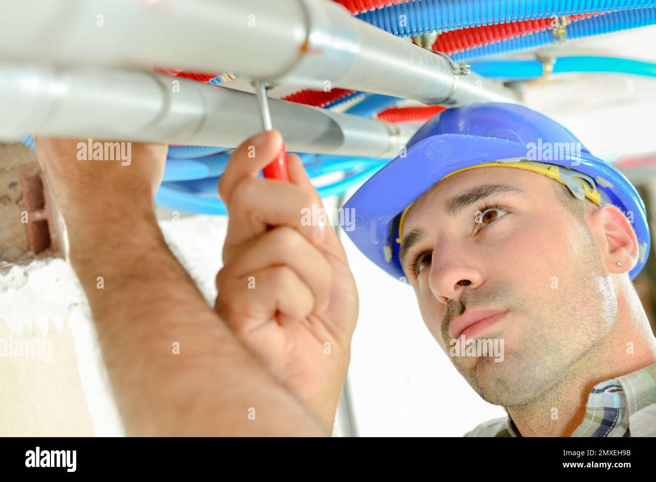 a worker screwing a pipe Stock Photo - Alamy