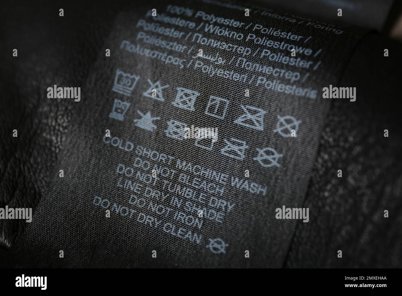 Clothing label with care symbols and material content on black shirt ...