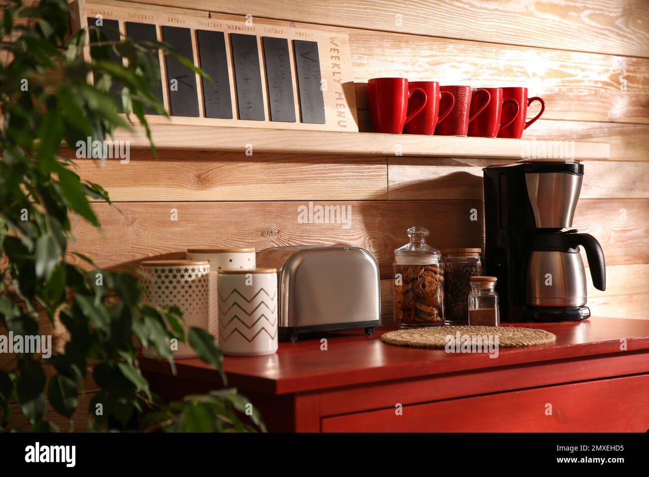 Stylish room interior with modern coffeemaker and toaster on red chest ...