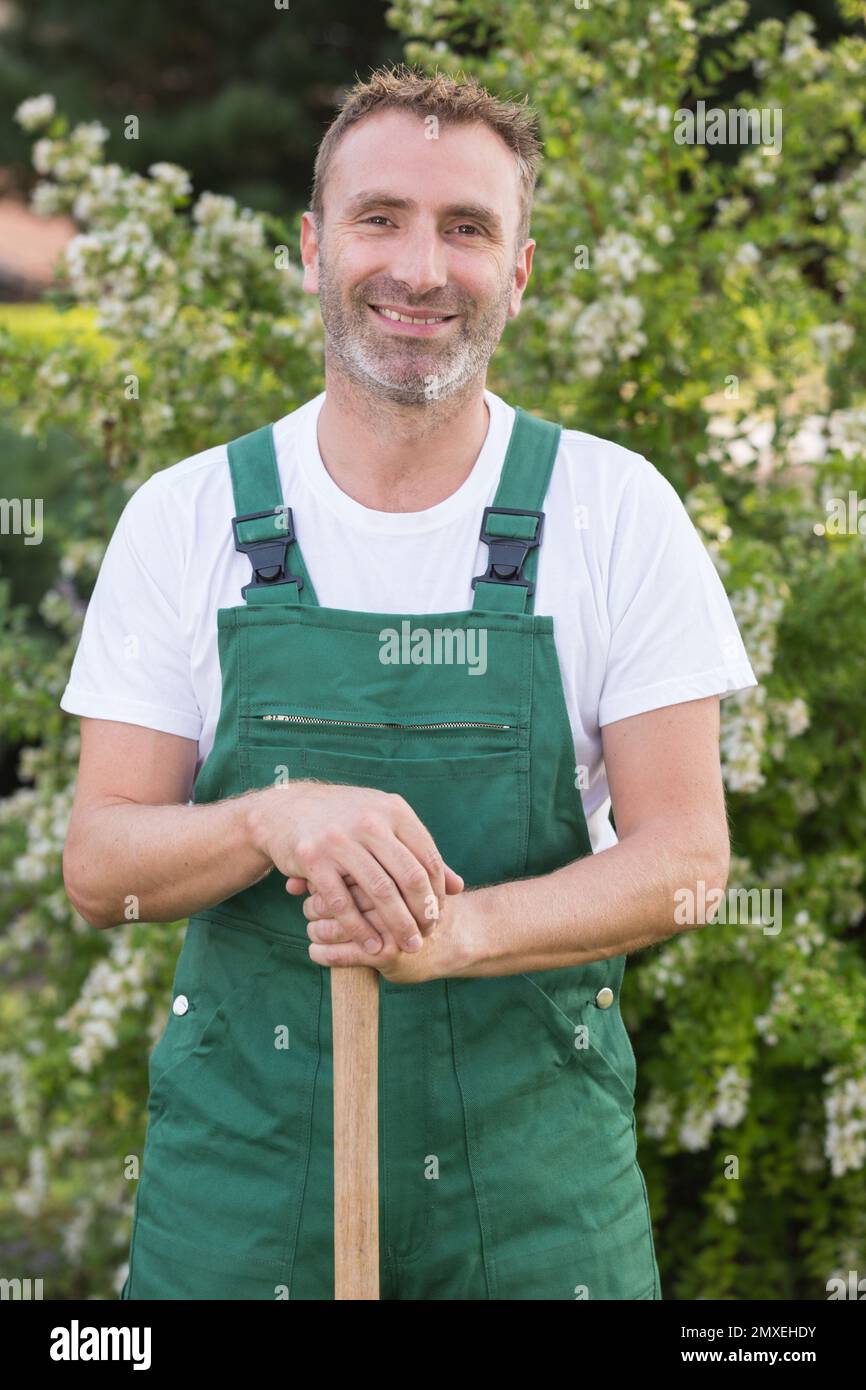 happy man is holding a rake Stock Photo - Alamy