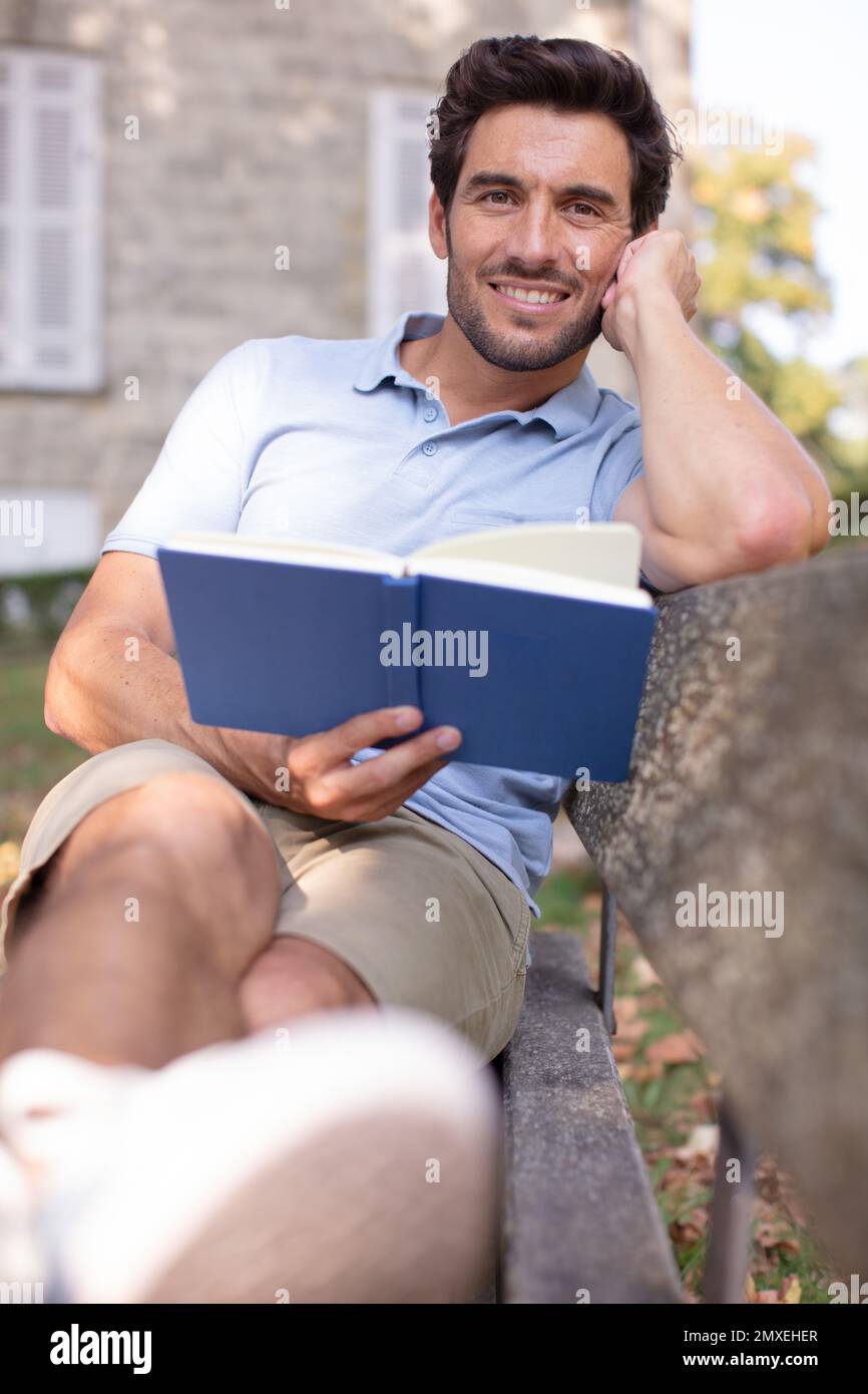 man on park bench reading a book Stock Photo - Alamy