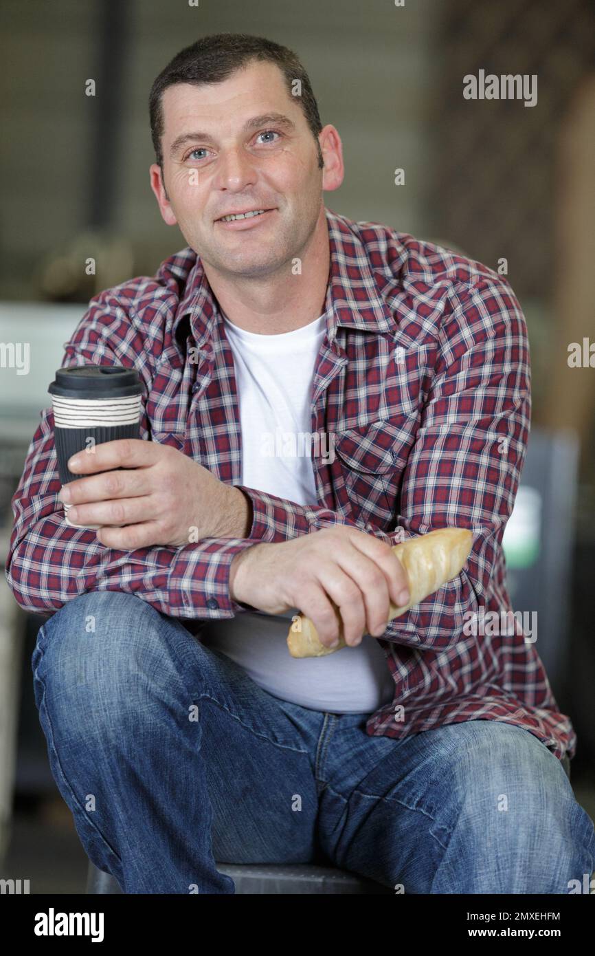 worker drinking coffee and resting sitting in factory Stock Photo - Alamy