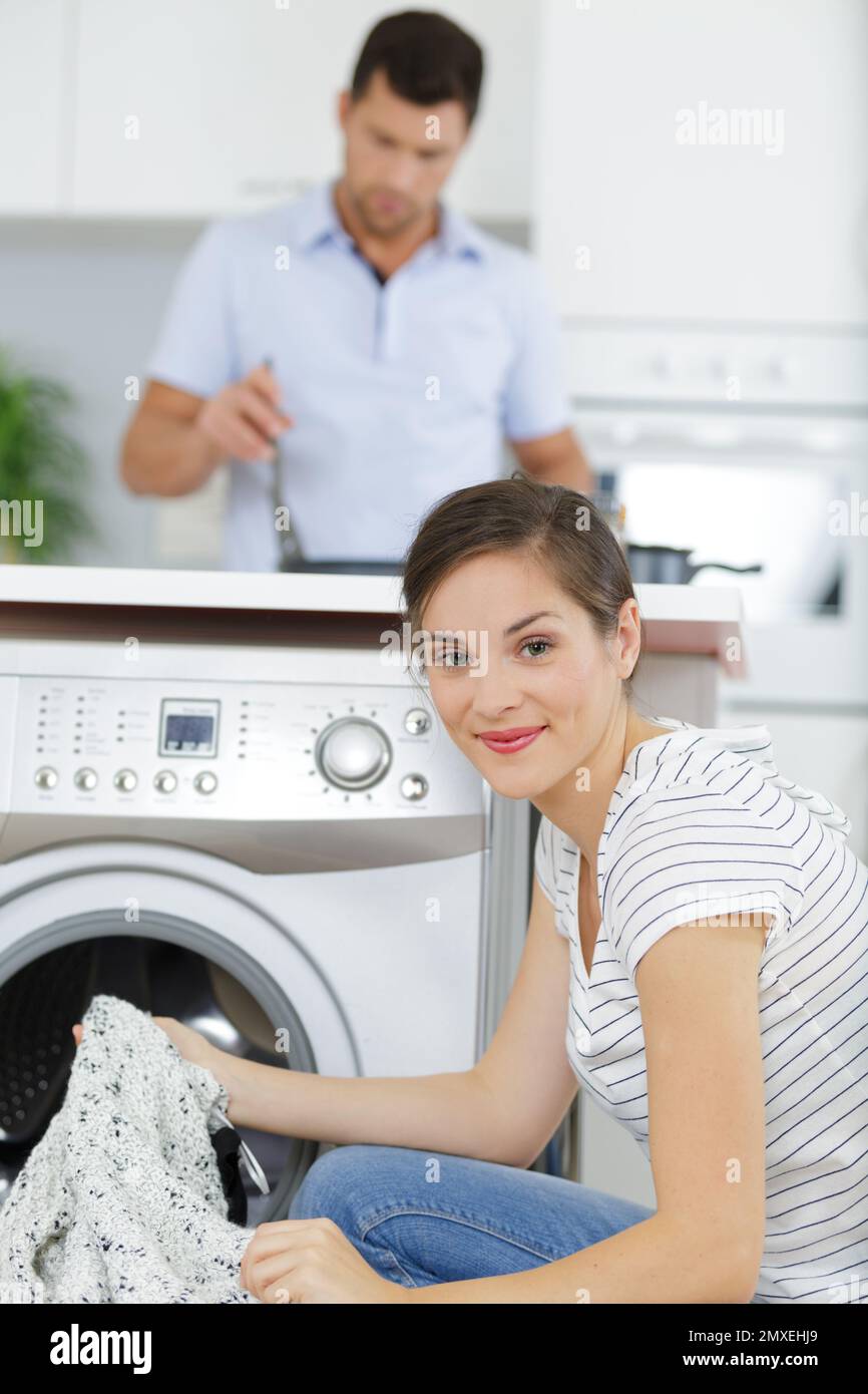 woman putting clothes in washing machine Stock Photo - Alamy