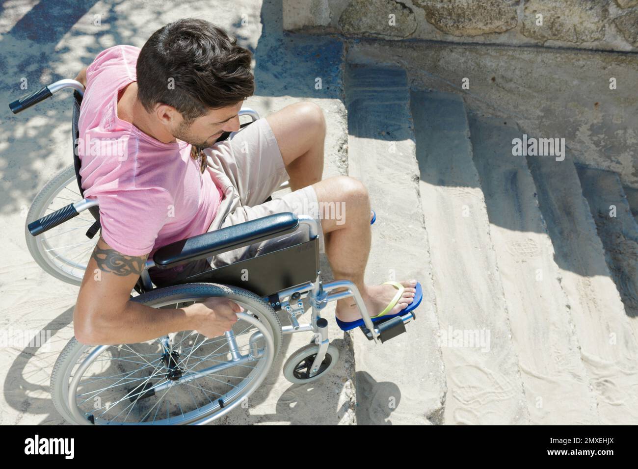 disabled man in a wheelchair waiting at top of steps Stock Photo - Alamy