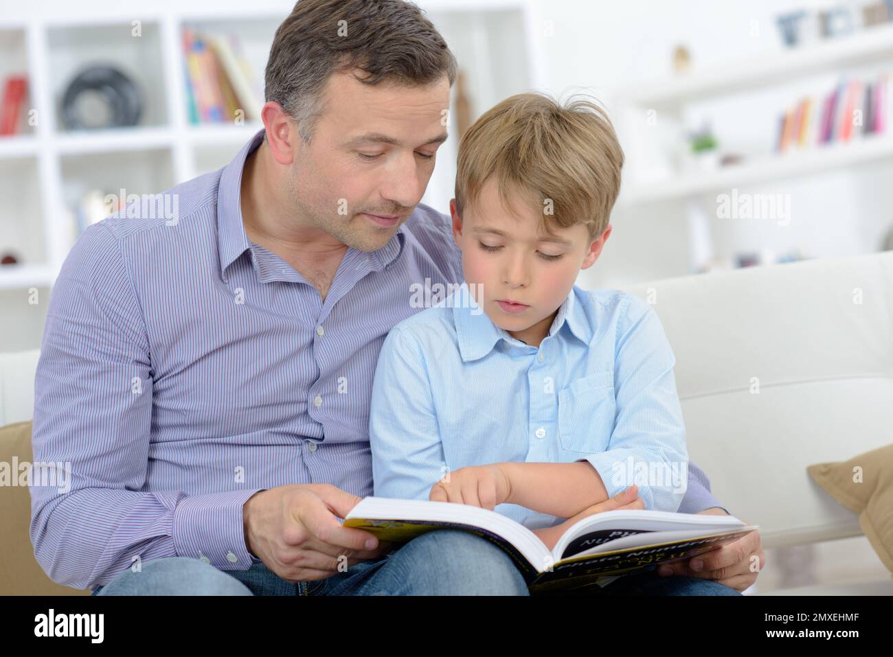 dad and his son reading a book Stock Photo - Alamy