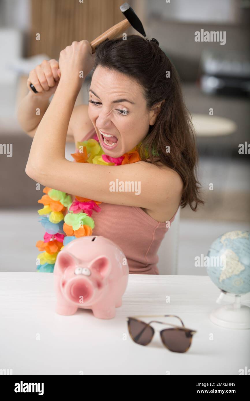 ferocious woman smashing piggybank with hammer Stock Photo - Alamy