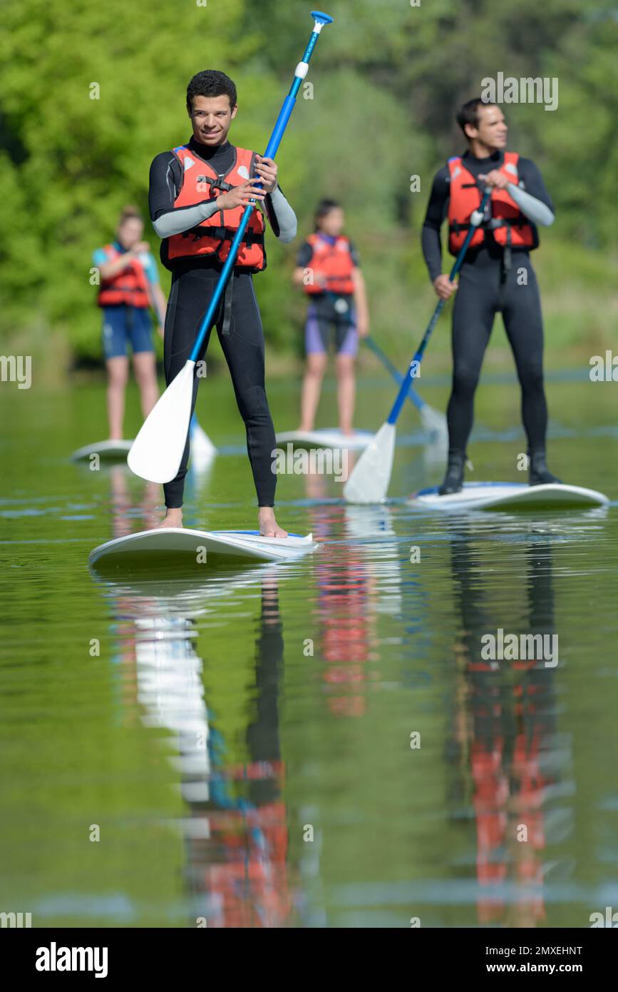 group of people peddle boarding on lake Stock Photo - Alamy