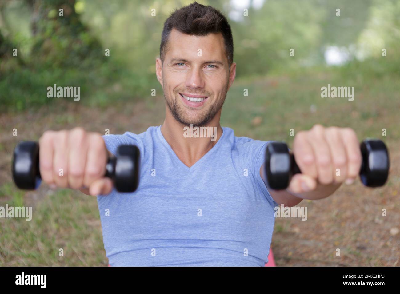 portrait of man holding dumbbell Stock Photo - Alamy