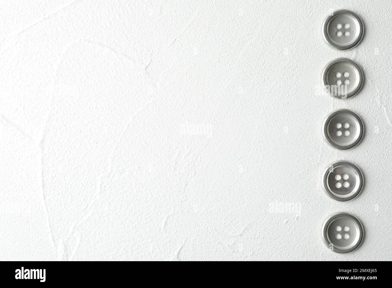 Metal sewing buttons on white background, flat lay. Space for text ...