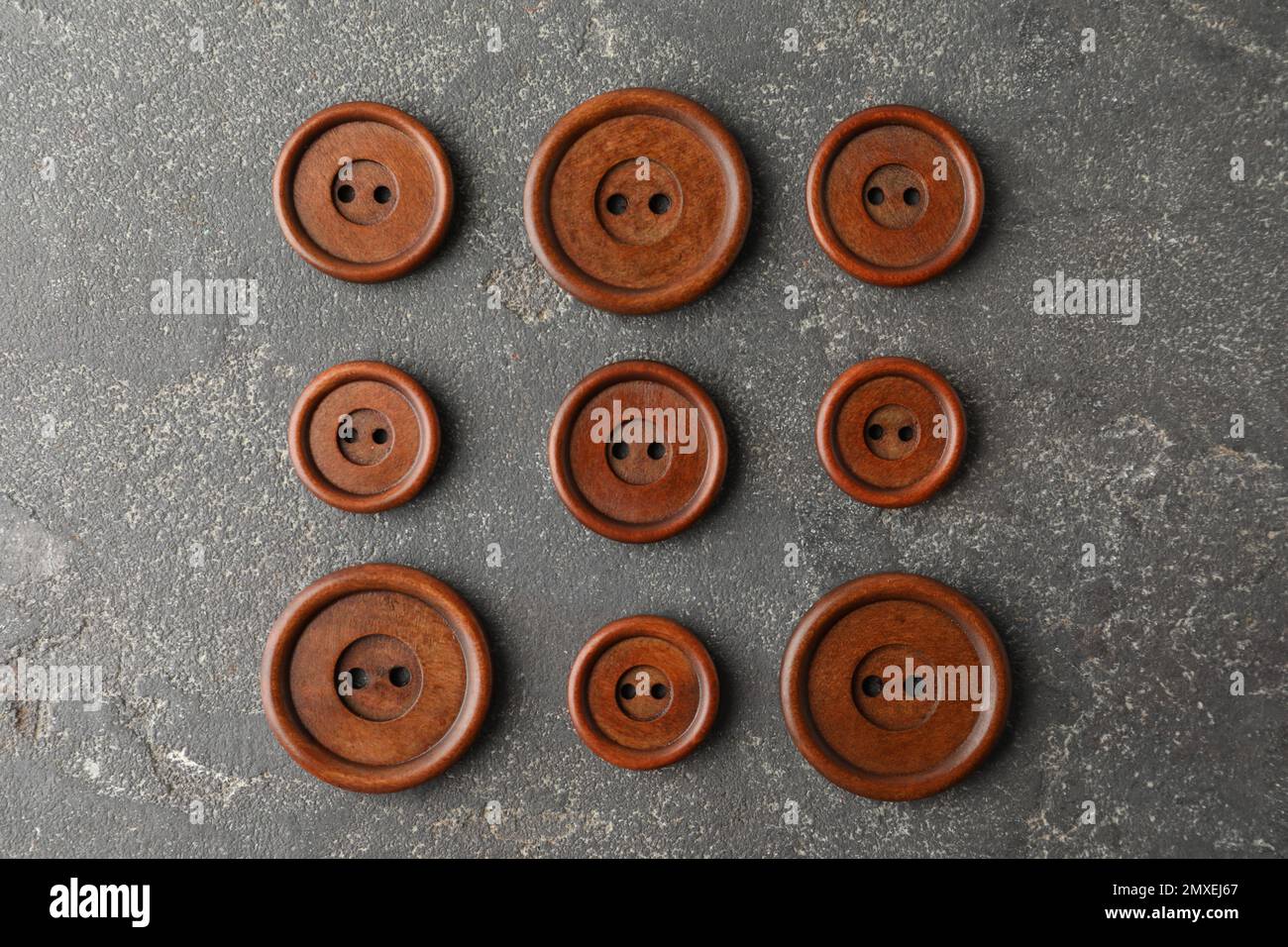 Brown sewing buttons on grey stone background, flat lay Stock Photo - Alamy