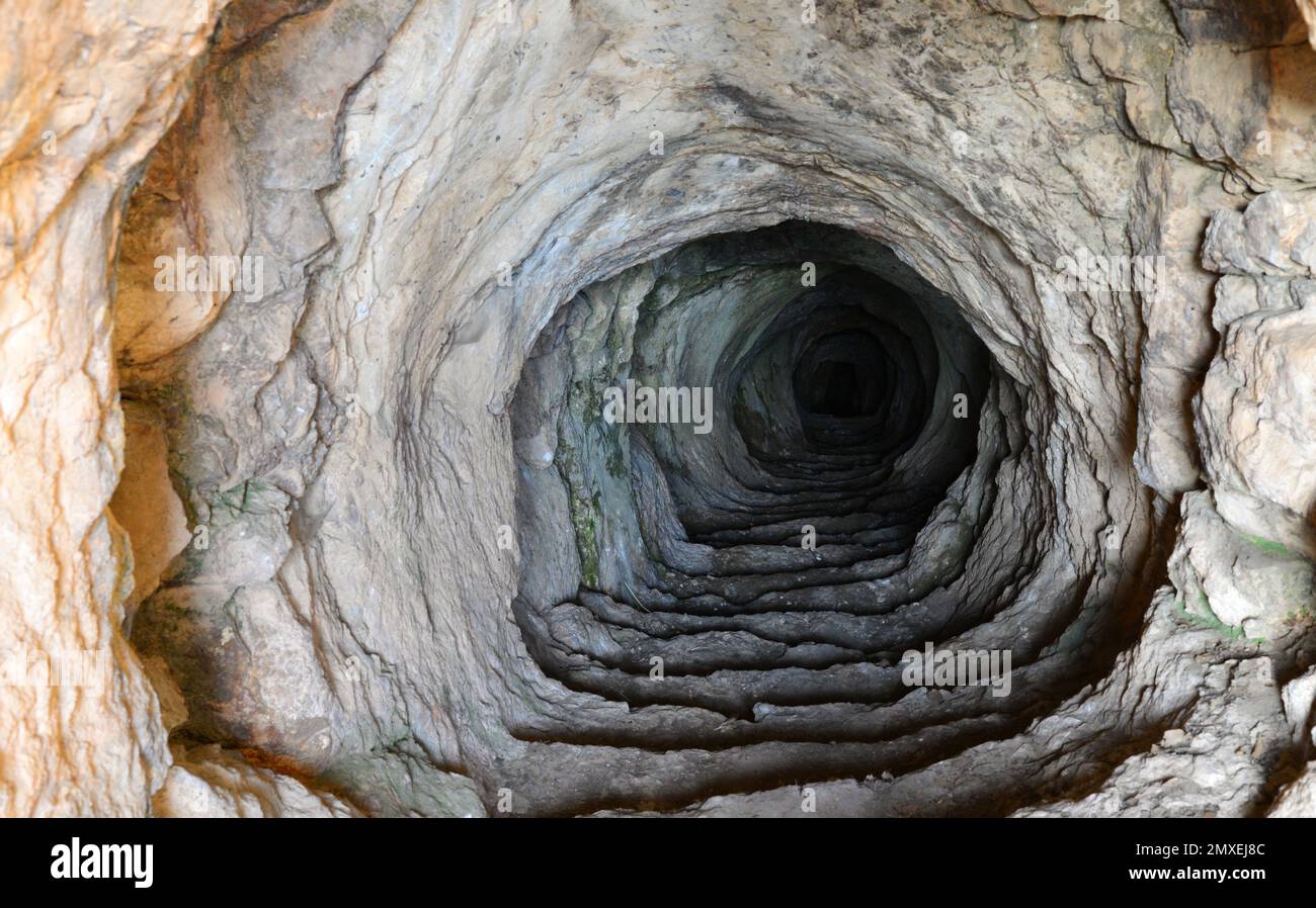 A narrow mine tunnel in a stone cave Stock Photo - Alamy