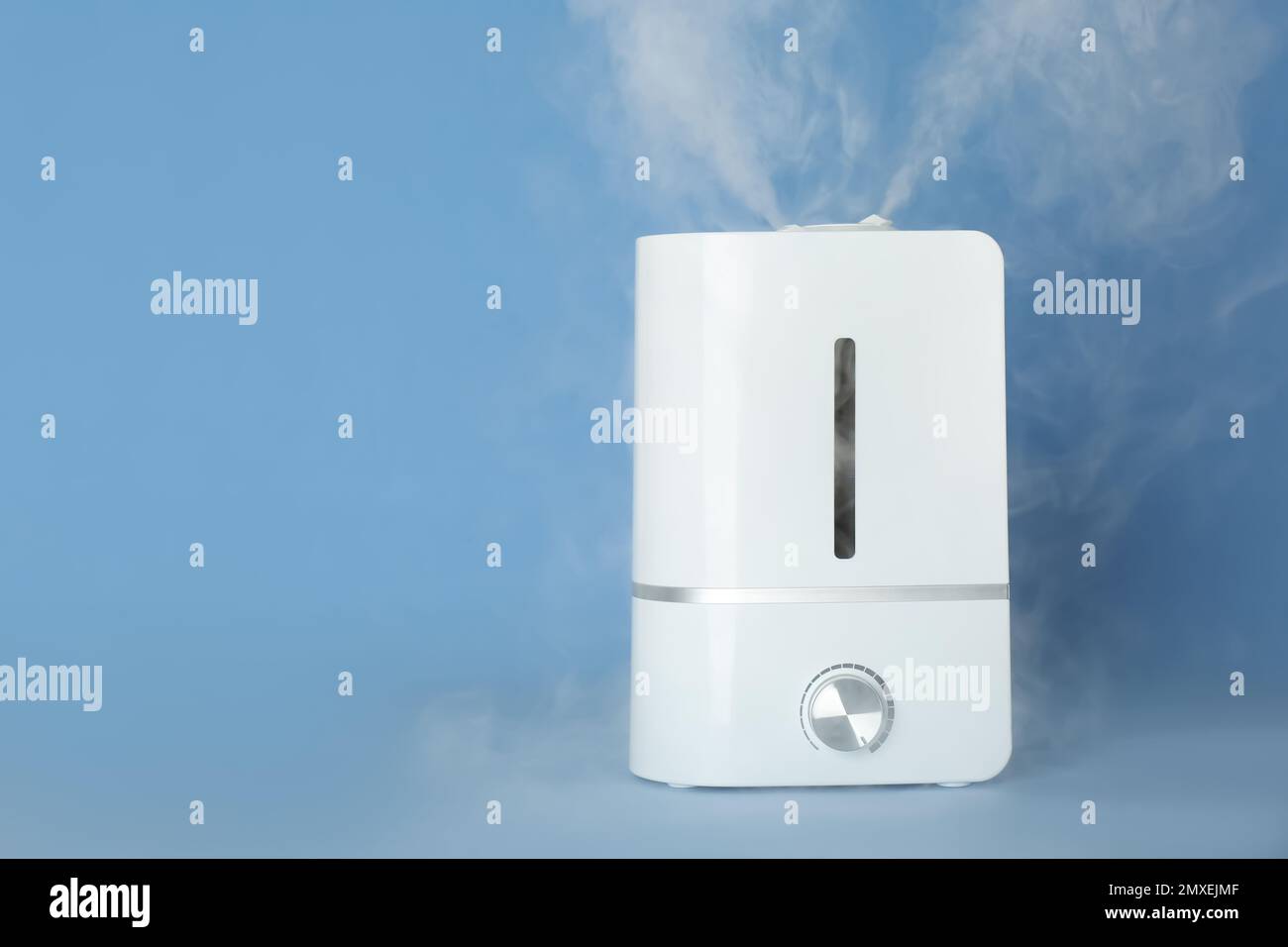 Modern air humidifier on light blue background. Space for text Stock ...