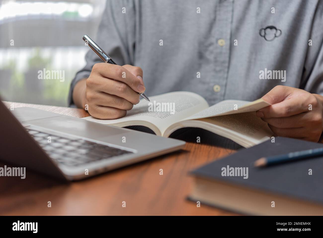 learning online class by using laptop computer and writing notebook at ...