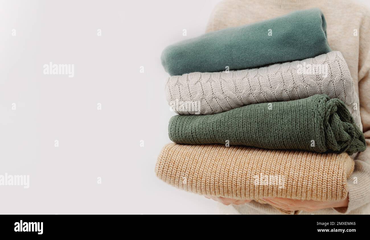 Woman's hand holding a stack of clothes. Clothes Donation, Renewable ...