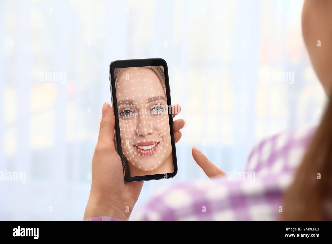 Woman Using Smartphone With Facial Recognition System On Blurred