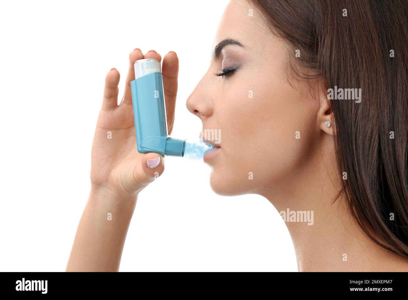 Young woman using asthma inhaler on white background Stock Photo - Alamy