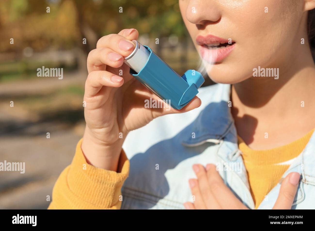Woman using asthma inhaler outdoors, closeup. Health care Stock Photo ...