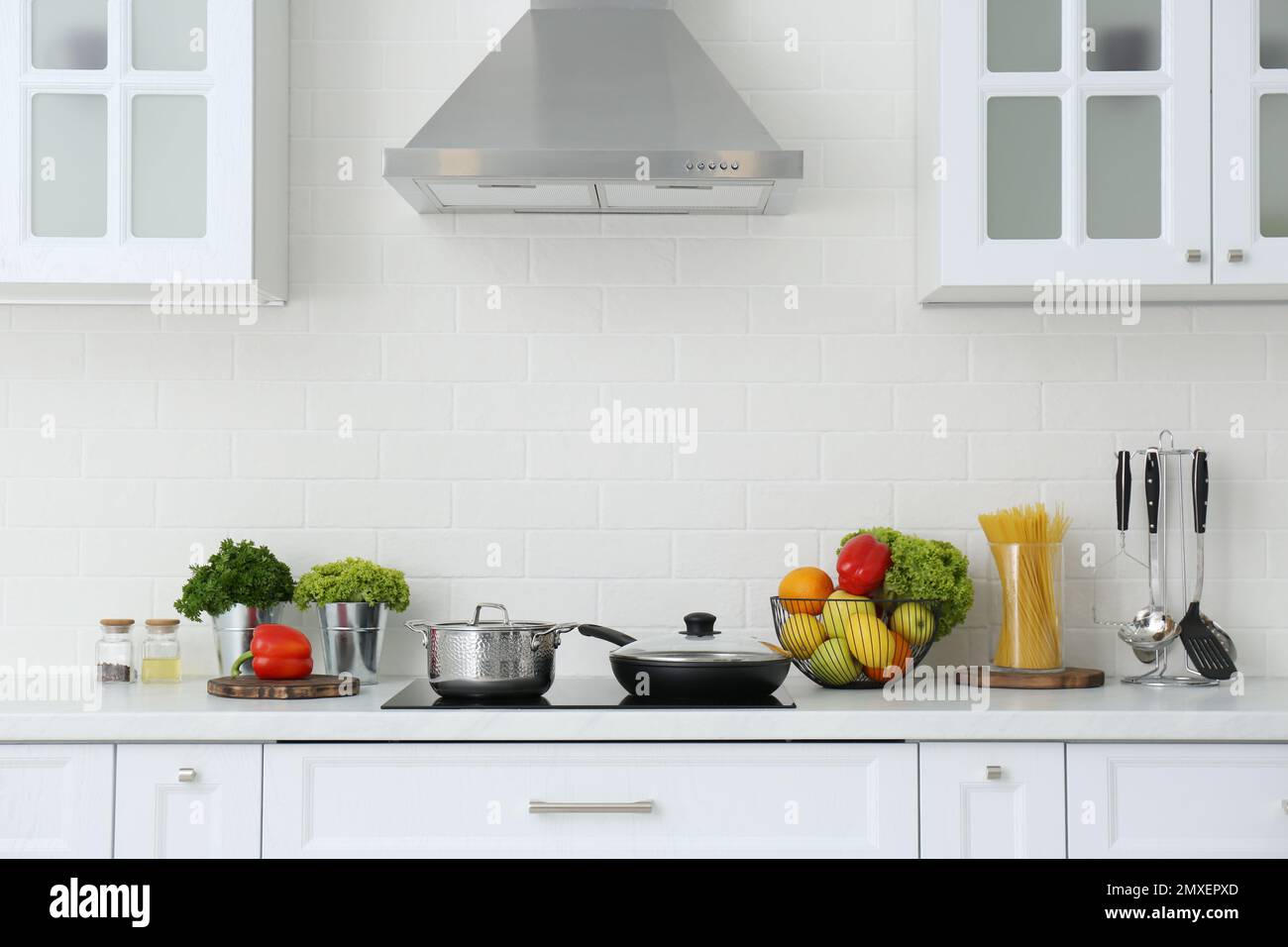 Counter with set of dishware, utensils and products in stylish kitchen ...