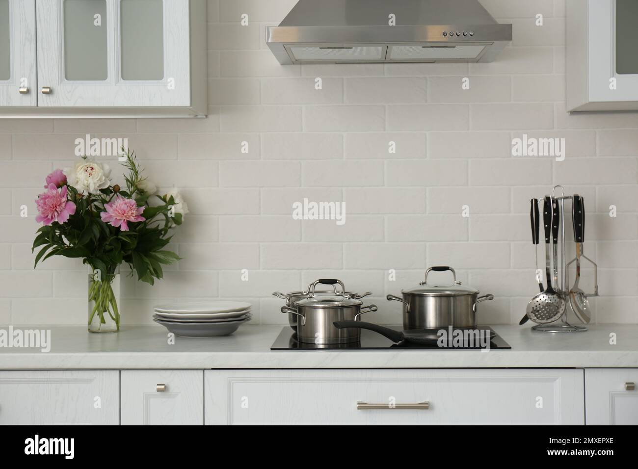Kitchen counter with set of dishware, utensils and beautiful bouquet ...