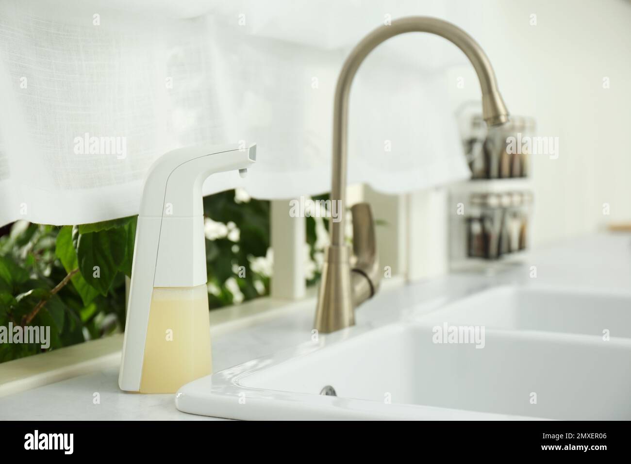 Modern automatic soap dispenser near sink in kitchen Stock Photo - Alamy