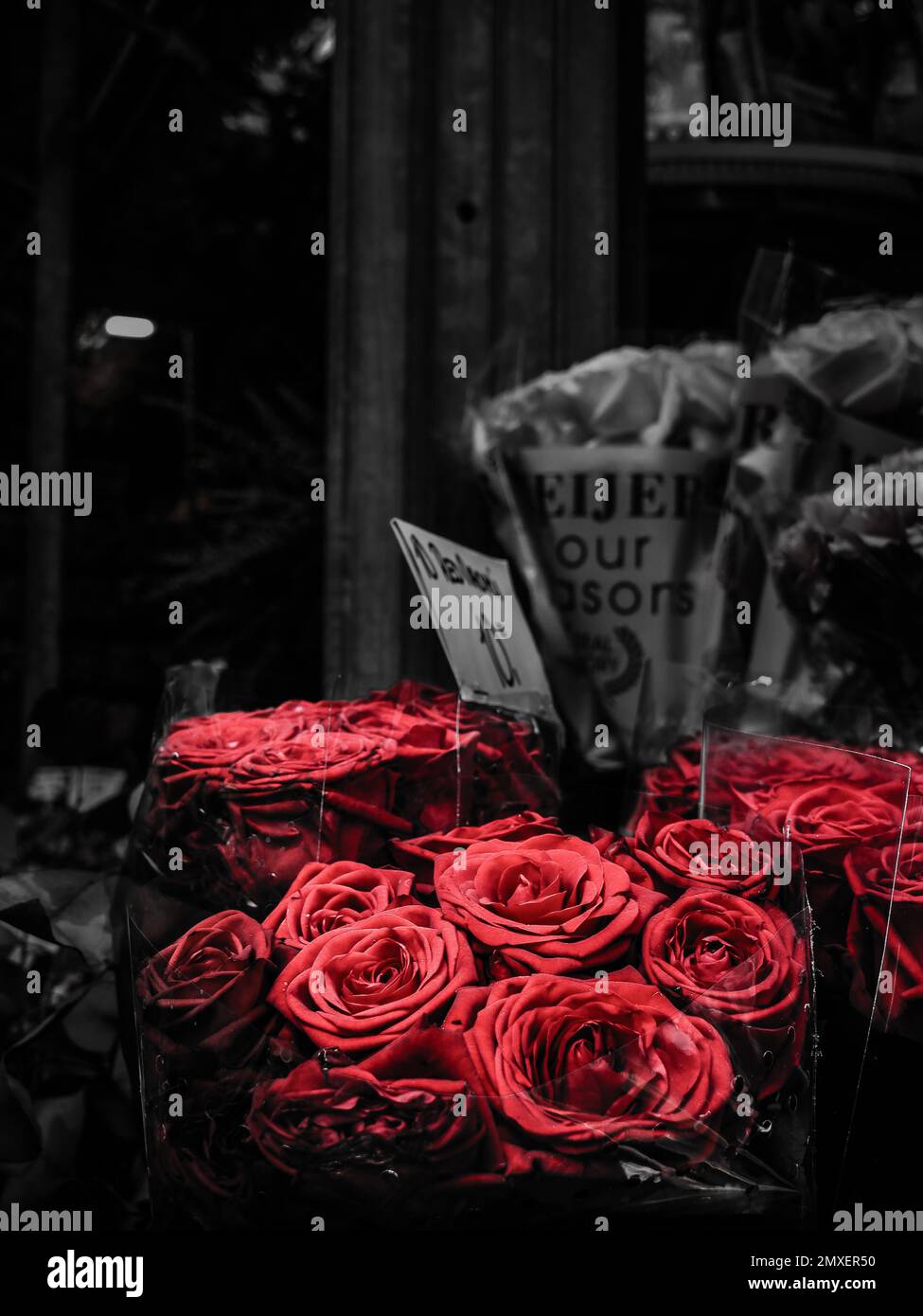 A selective color of bouquets of red roses being sold outdoors on the ...