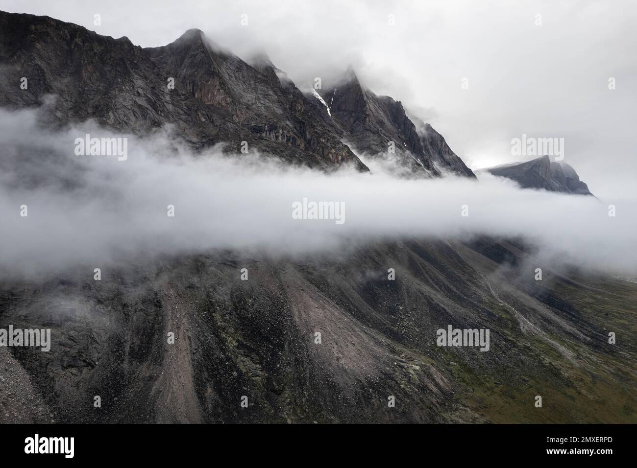 Dark atmospheric surreal landscape with dark rocky mountain top in low ...