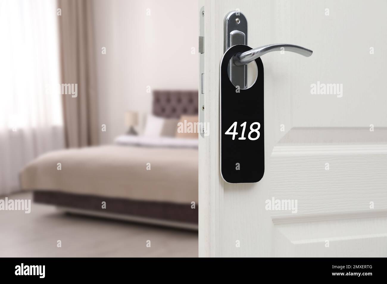 Open door with sign 418 on handle in hotel, closeup. Space for text ...