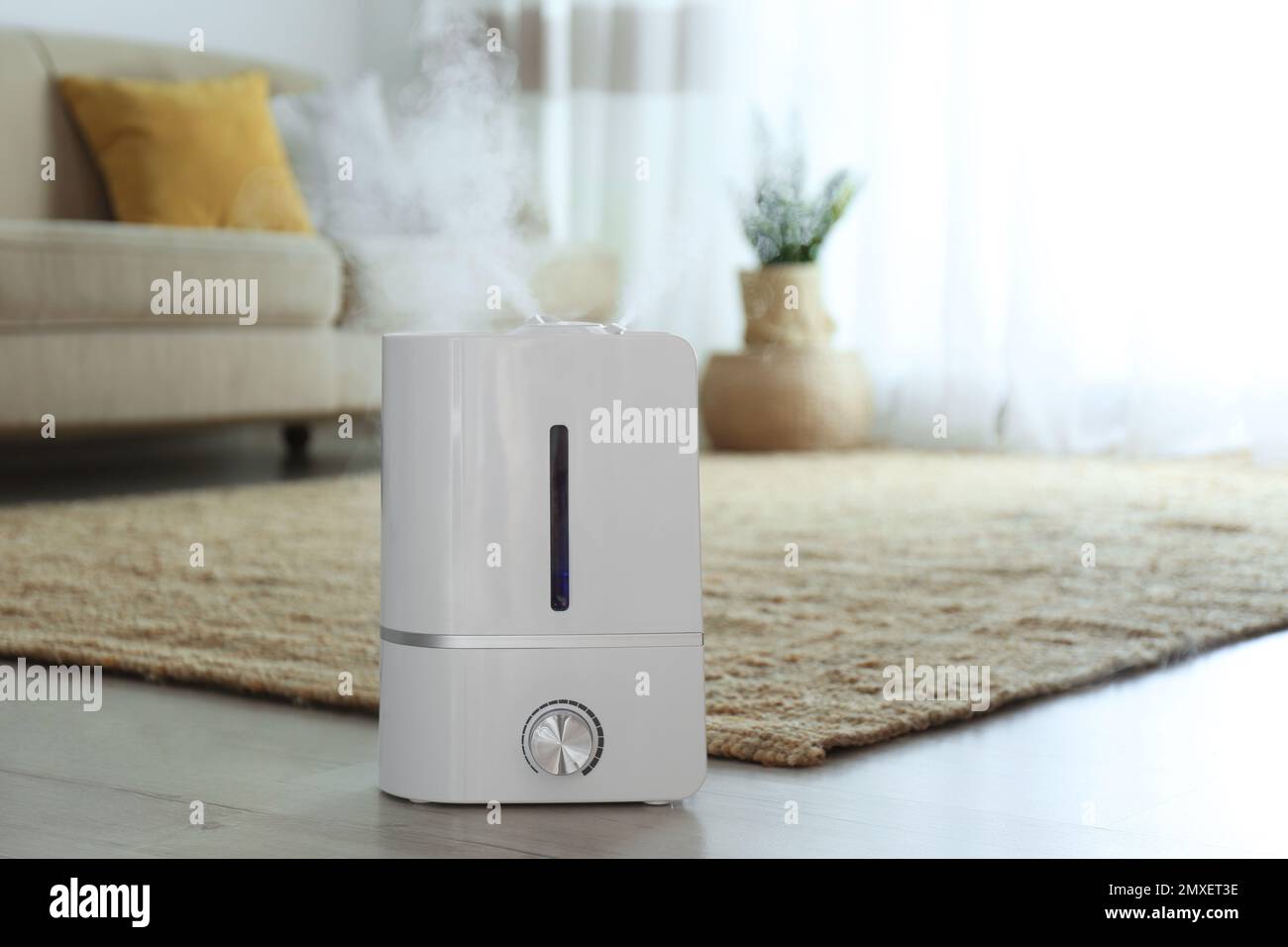 Modern air humidifier on floor indoors. Space for text Stock Photo - Alamy
