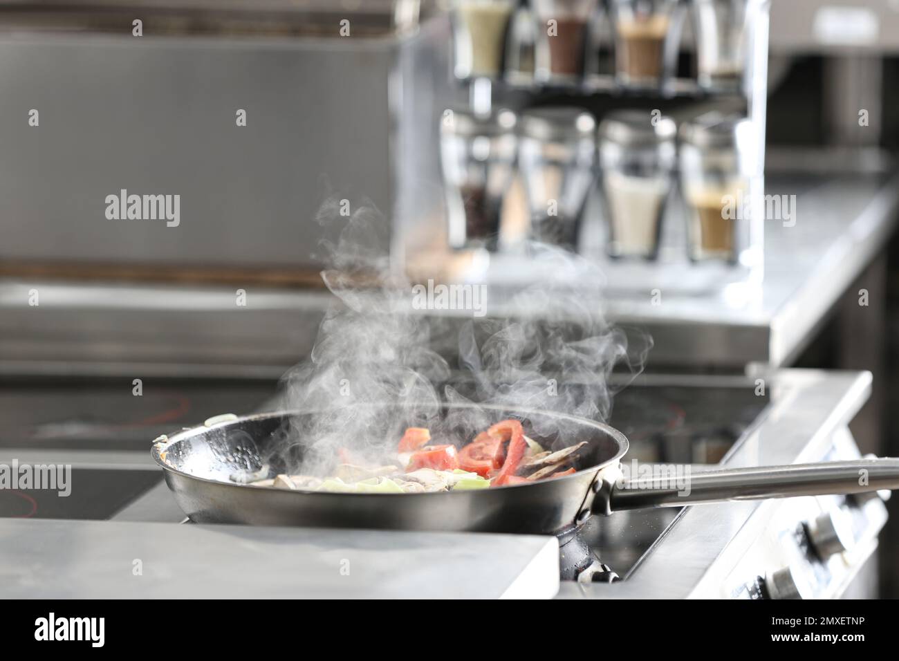 Cooking tasty food on stove in restaurant kitchen Stock Photo - Alamy