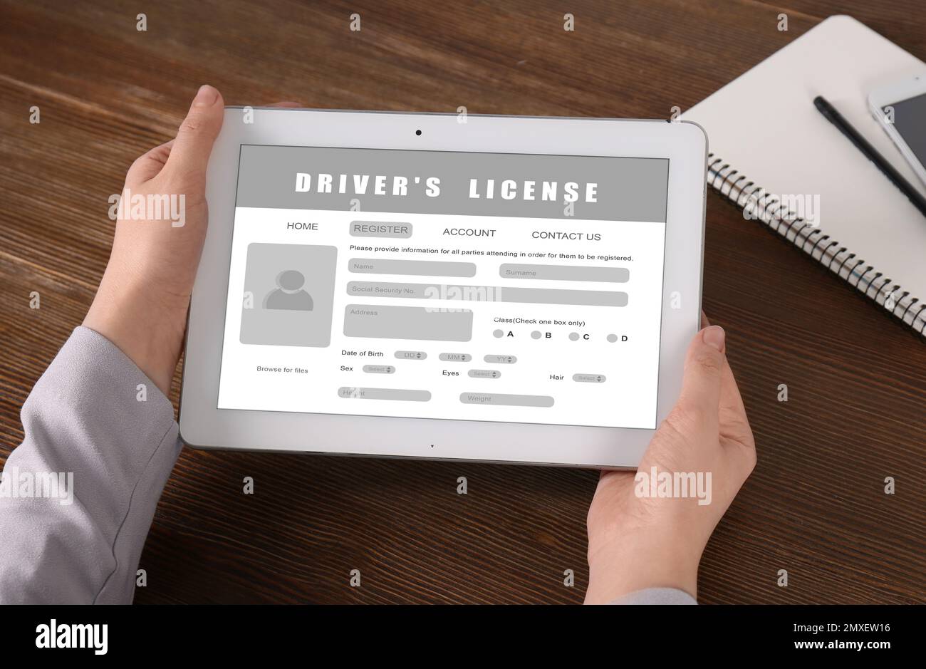 Woman filling in driver's license form online on website using tablet ...