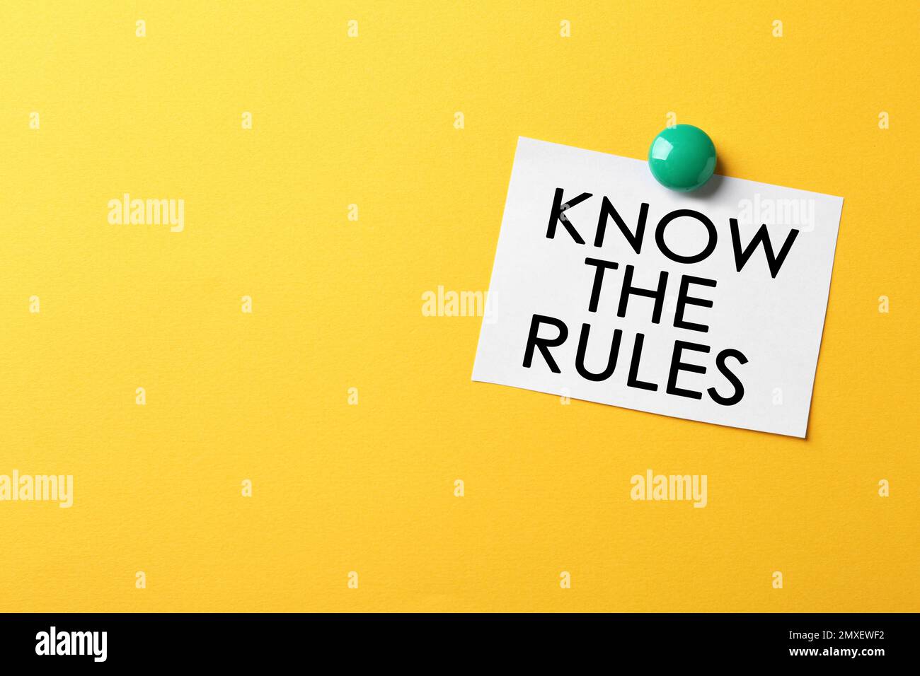 Paper note with phrase Know the rules on yellow background, space for ...