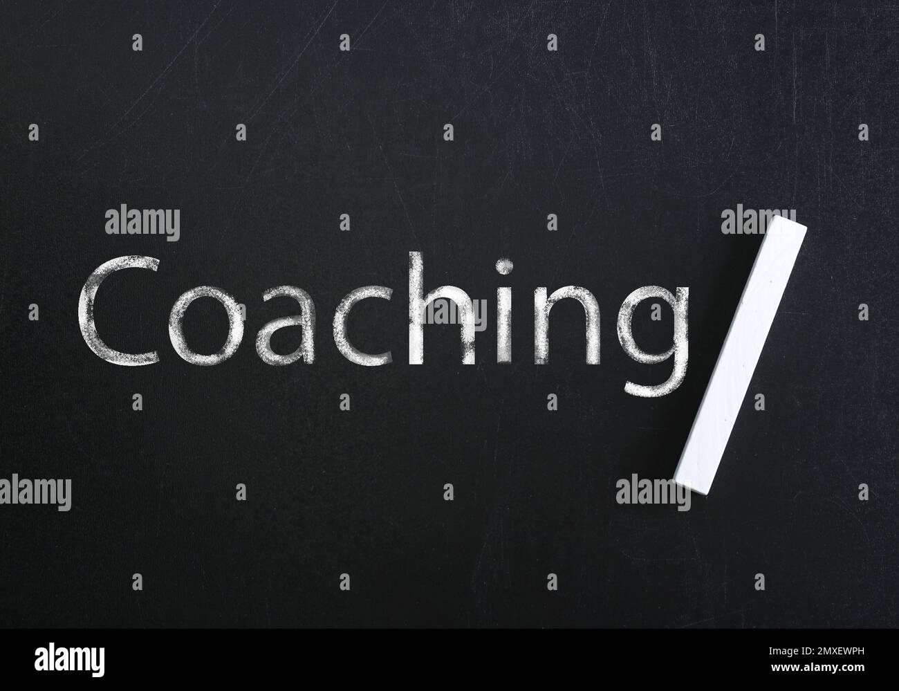 Adult learning. Piece of white chalk and word Coaching on black ...