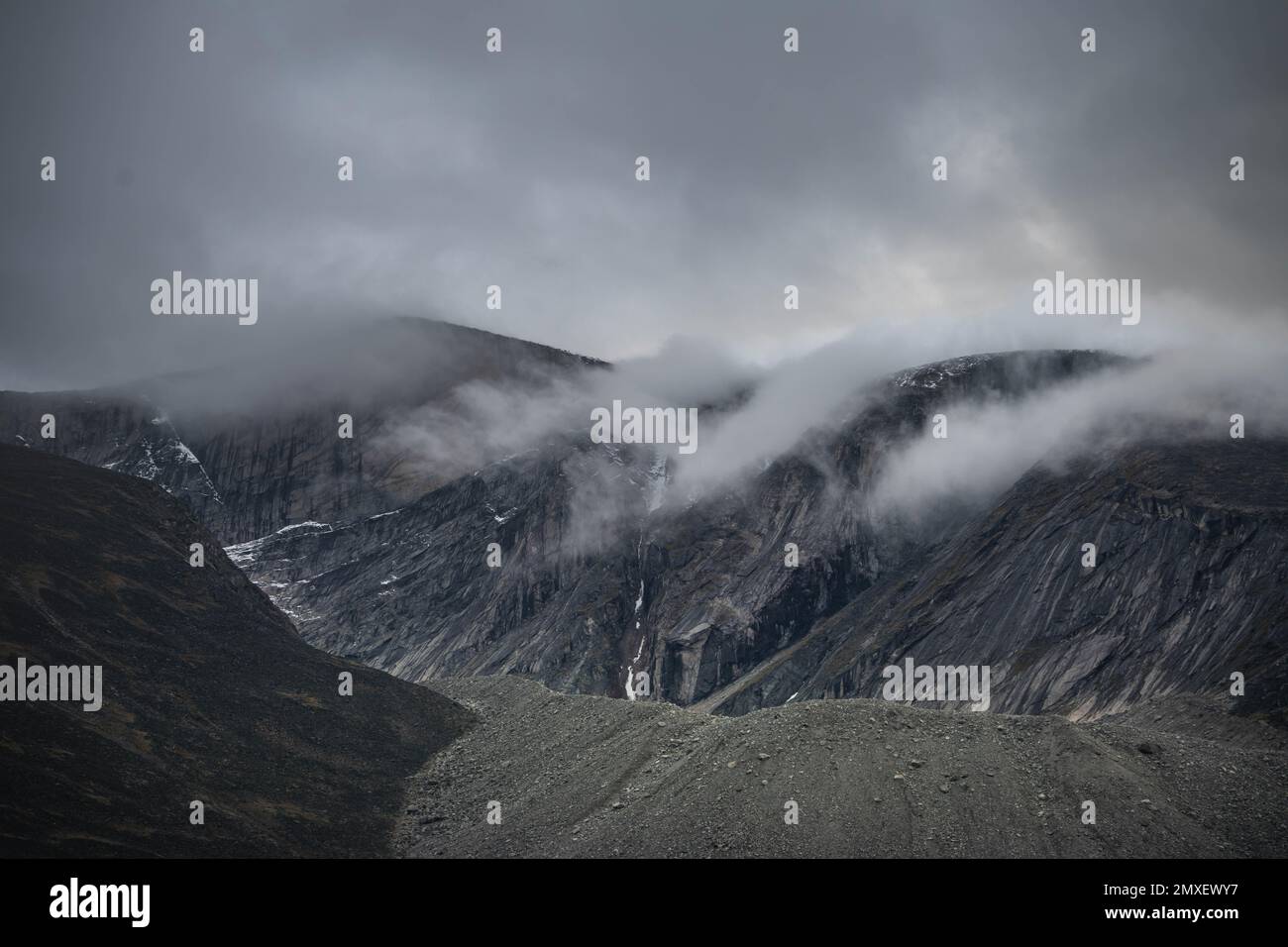 Dark atmospheric surreal landscape with dark rocky mountain top in low ...