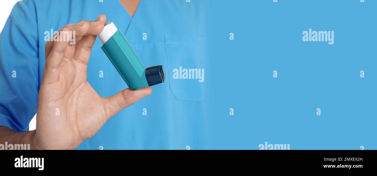 Closeup view of male doctor holding asthma inhaler, space for text ...