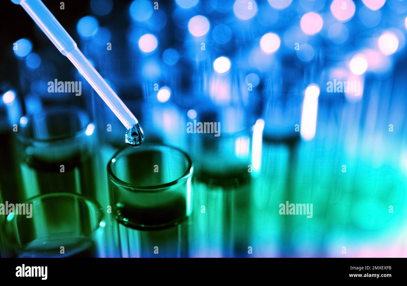 Dripping reagent into test tube with liquid sample, closeup. Laboratory ...