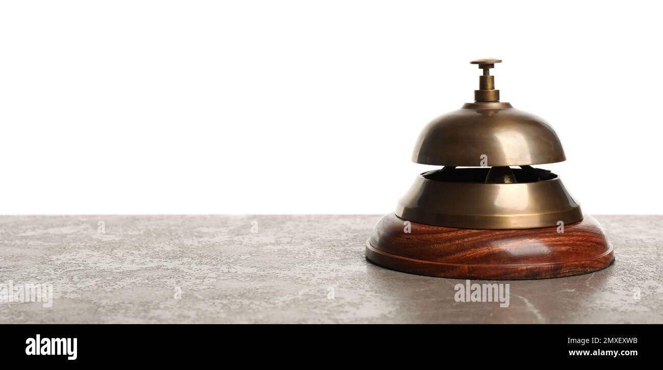 Hotel service bell on grey stone table against white background Stock ...