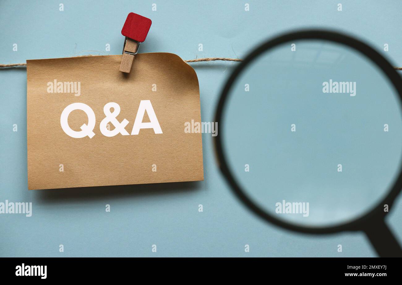 Brown paper hanging on the rope written with letter Q, A and ampersand ...